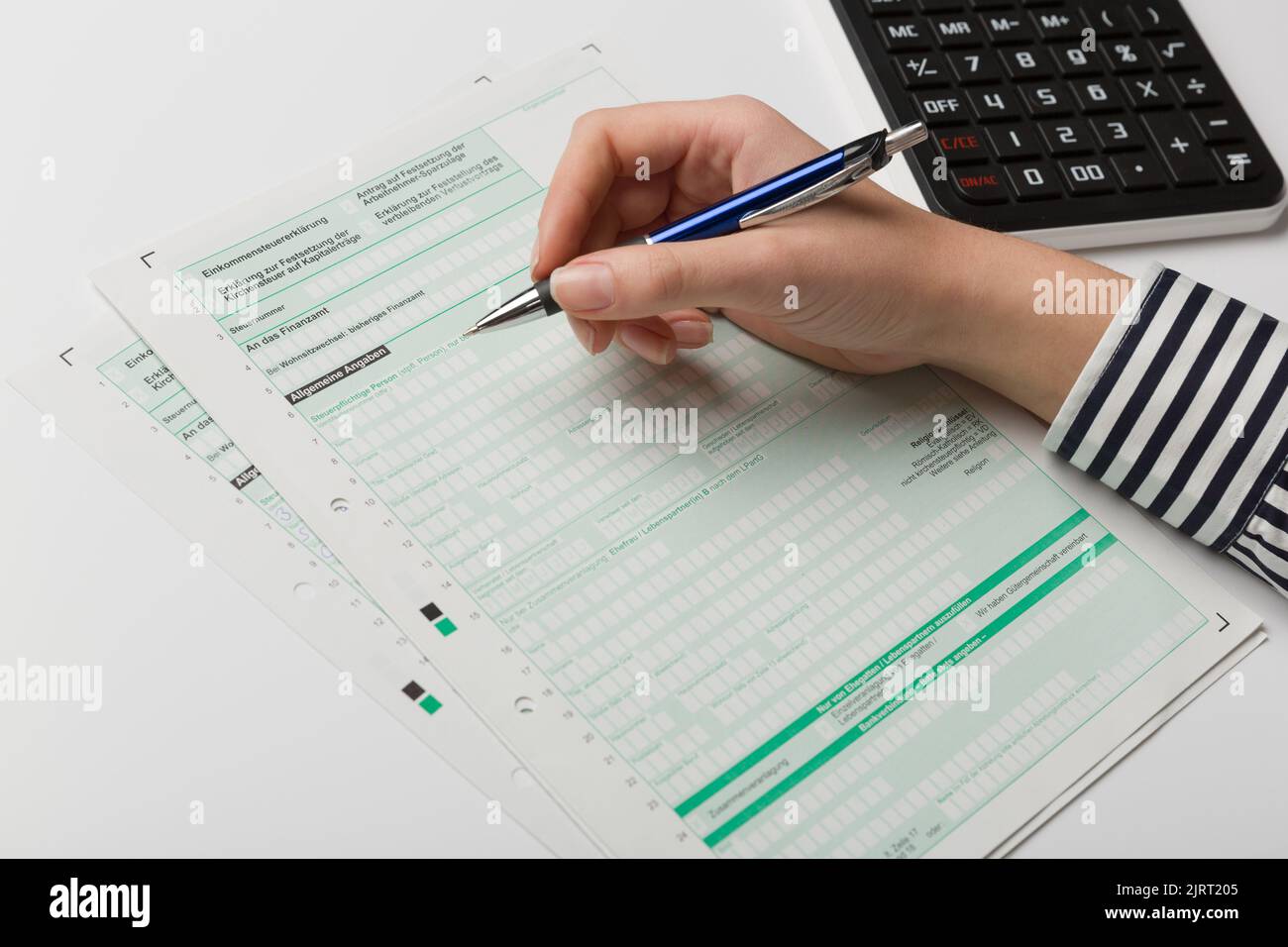 Close-Up of woman's hand fill out a tax declaration or tax return with ...