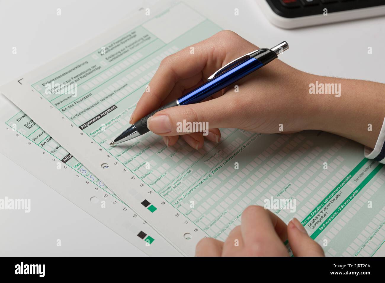 Close-Up of woman's hand fill out a tax declaration or tax return with ...