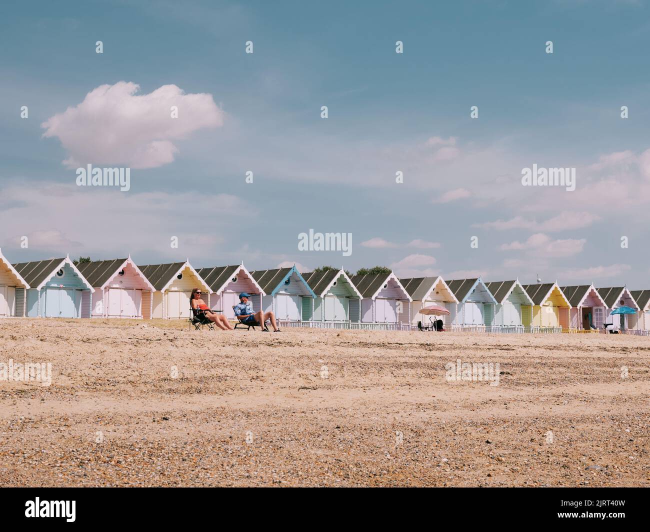 Pastel summer seaside beach huts and blue sky beach landscape in West ...