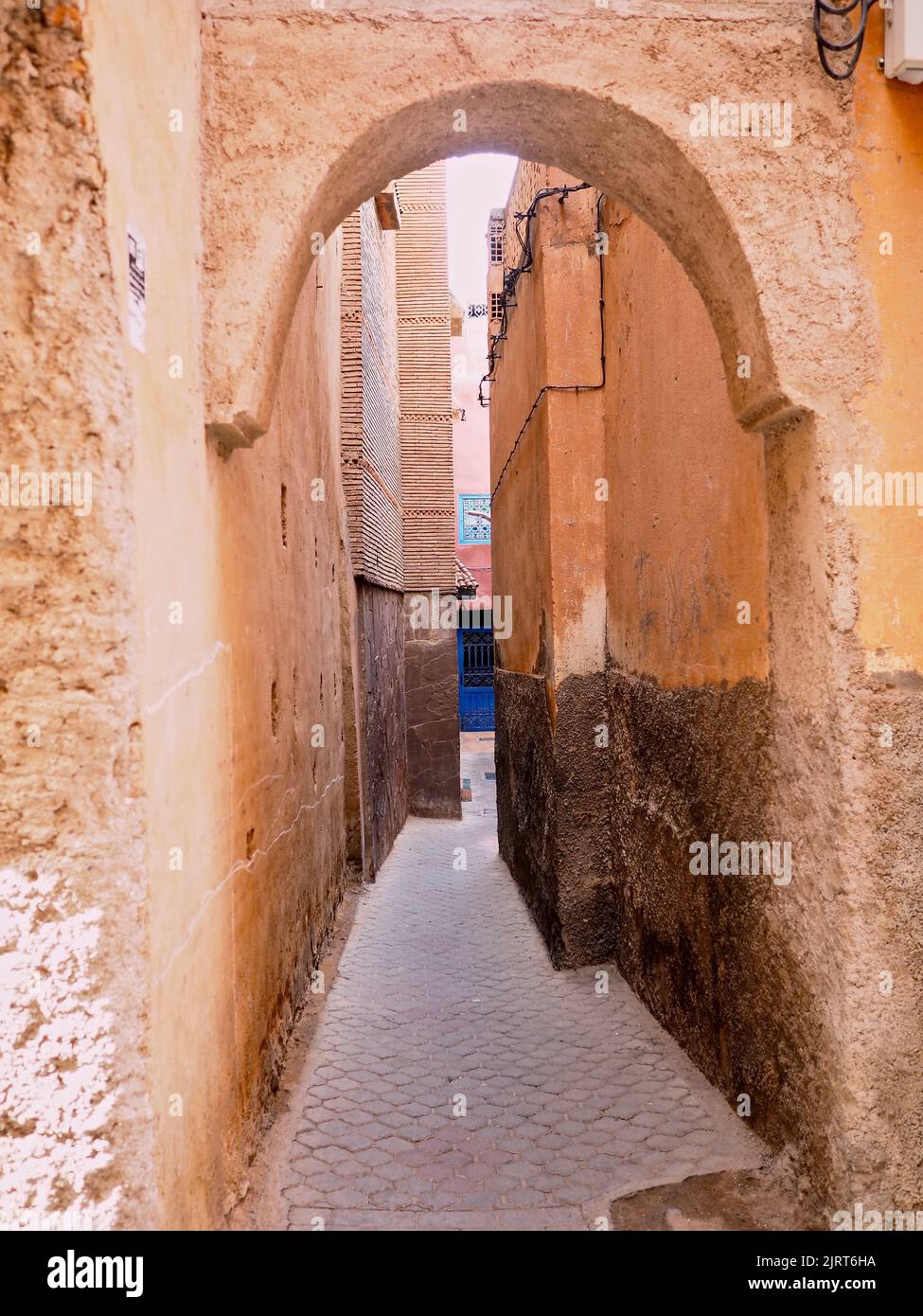 A vertical shot of a narrow path through an ancient arch in Marrakesh ...