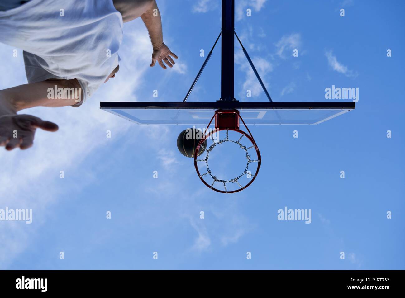 Man is training basketball on the street court. He throw ball to the ...