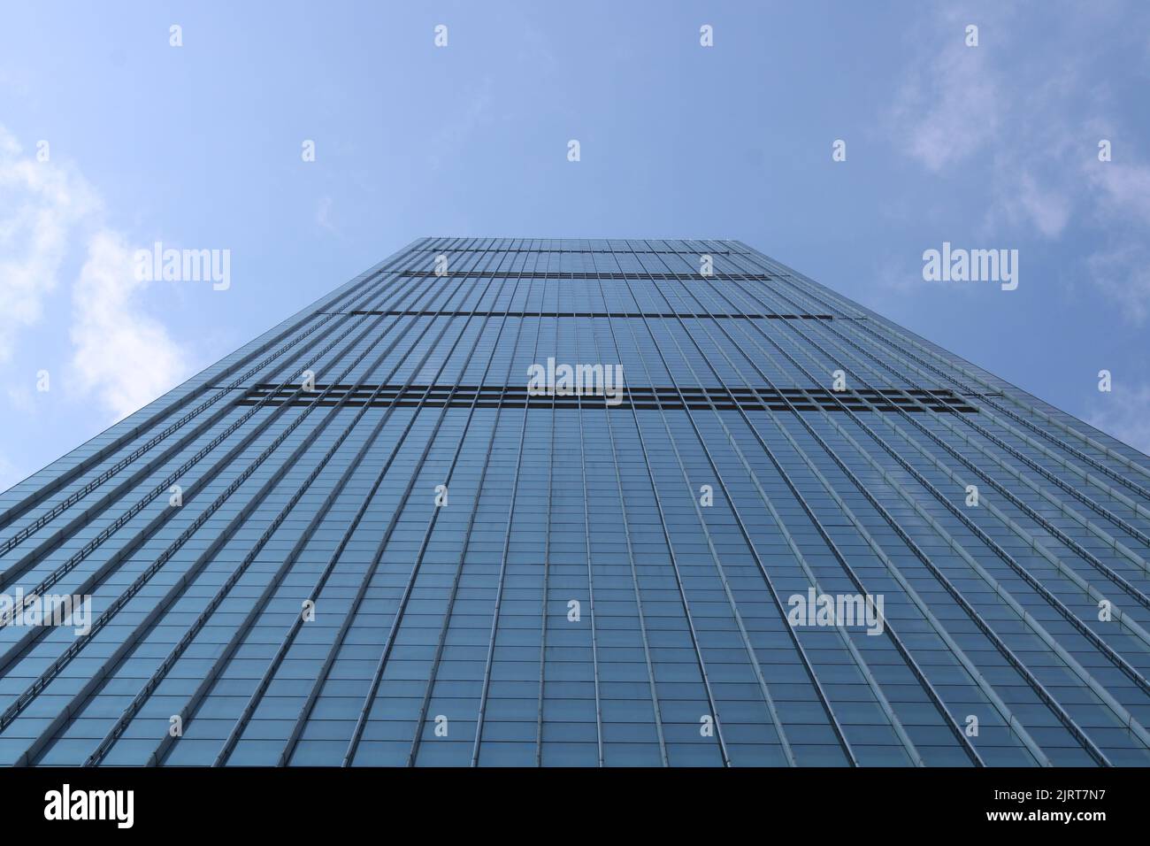A low angle of a modern glass building with cloudy sky background Stock ...