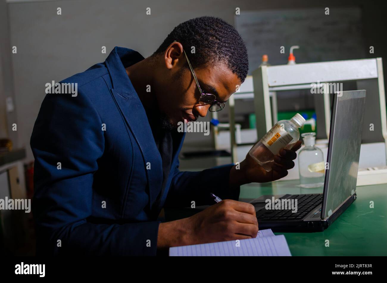 The pharmacist is reviewing the list of drugs and checking the stock of ...