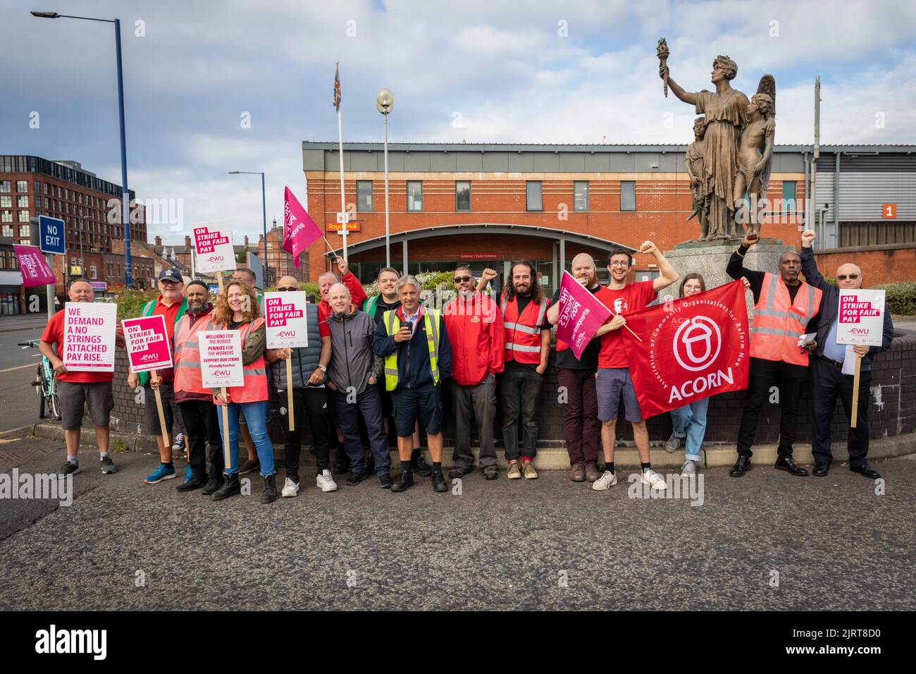 Royal Mail staff gather at the picket line while holding placards and ...