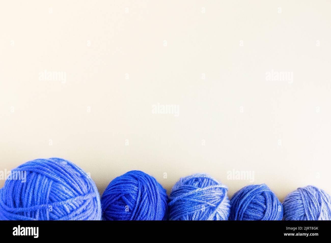Blue balls of knitting threads on a yellow background for knitting warm clothes Stock Photo - Alamy