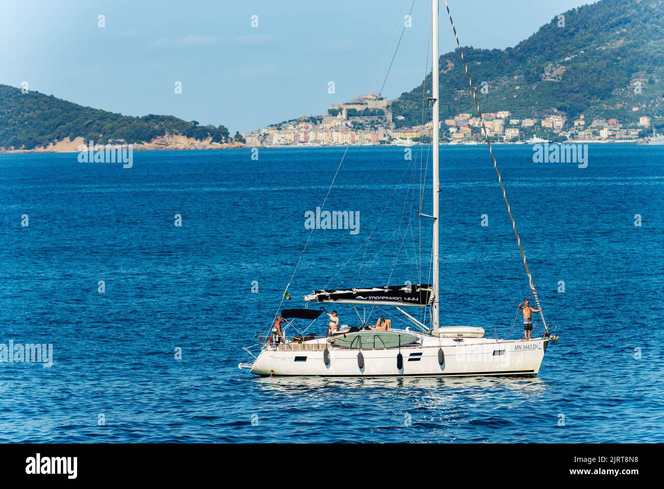 Sailboat with a group of people on board, in front of the Tellaro ...