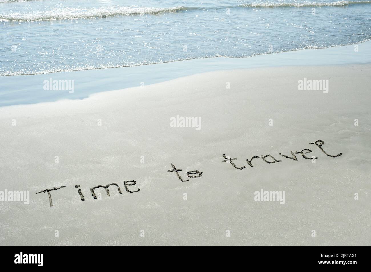 Concept or conceptual Time to travel handwritten text in sand on a ...