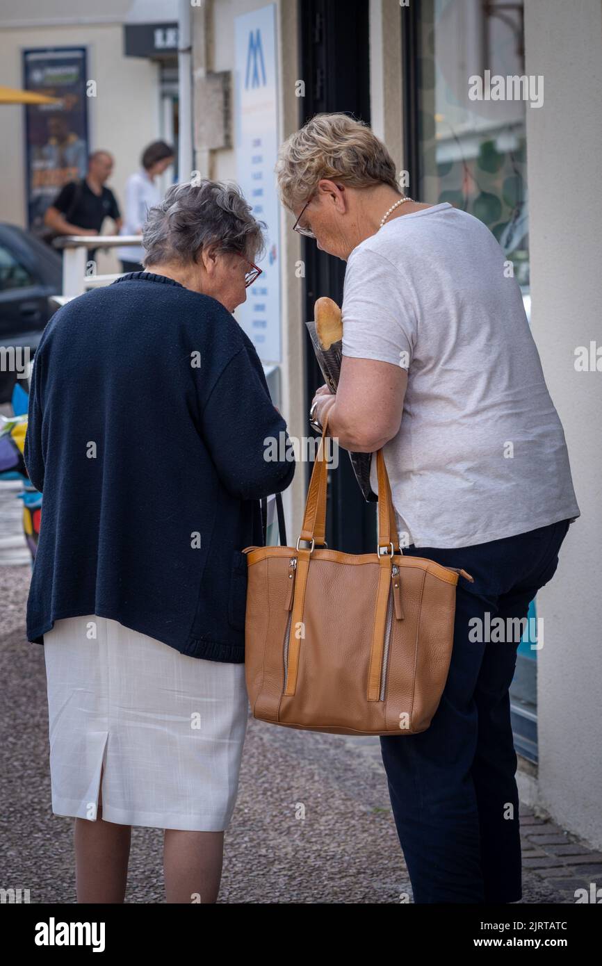 A vertical shot of two grandmothers leaving the bakery, who bought ...