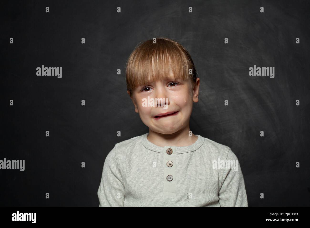 Small girl child crying over black background Stock Photo - Alamy