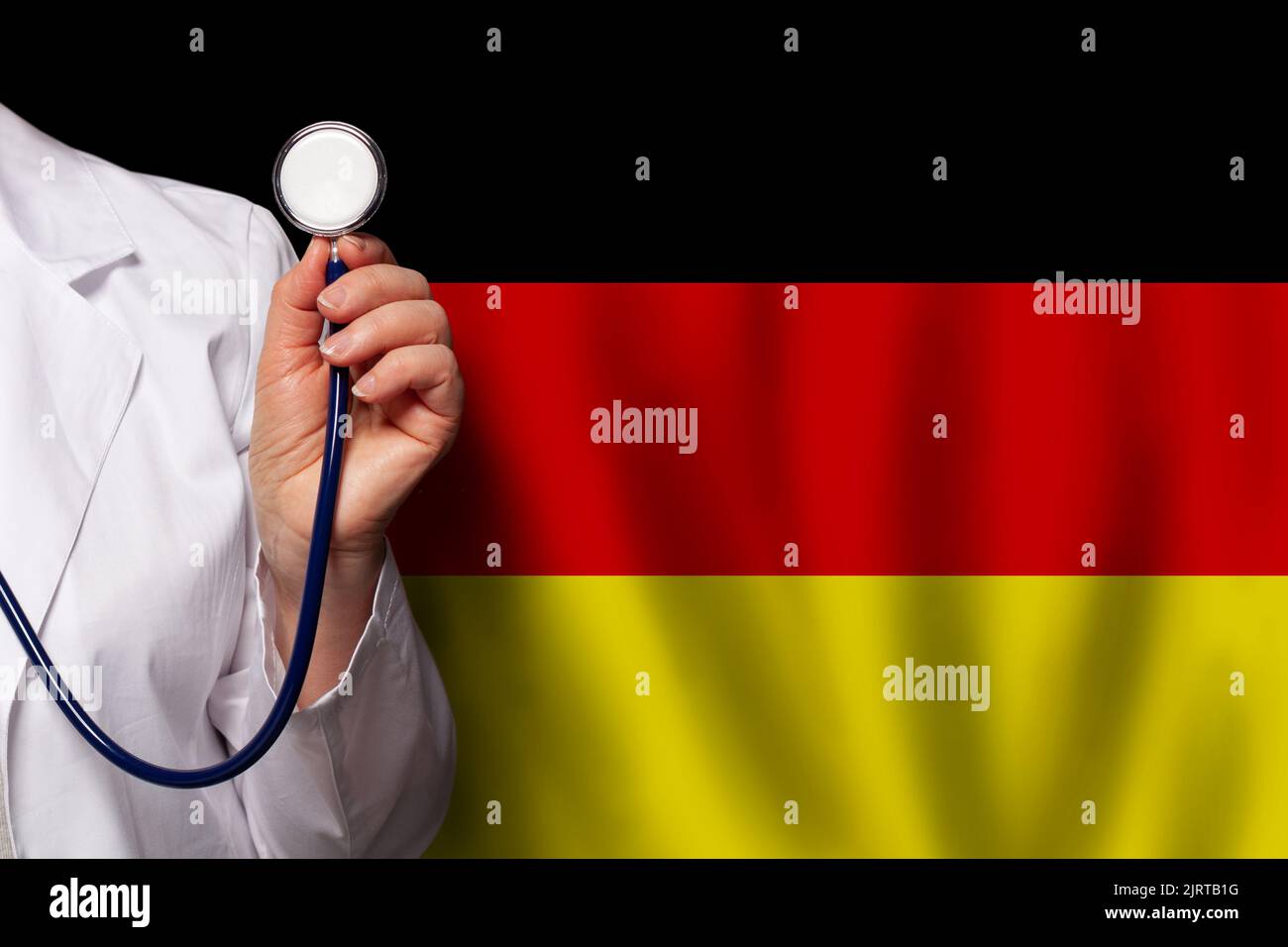 German medical worker's hand with stethoscope on flag of Germany ...