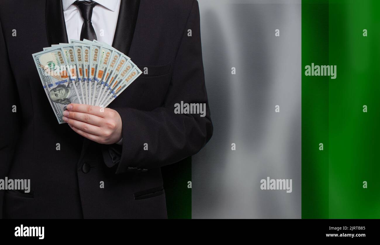 100 US dollar bills money banknotes in hand against flag of Nigeria ...