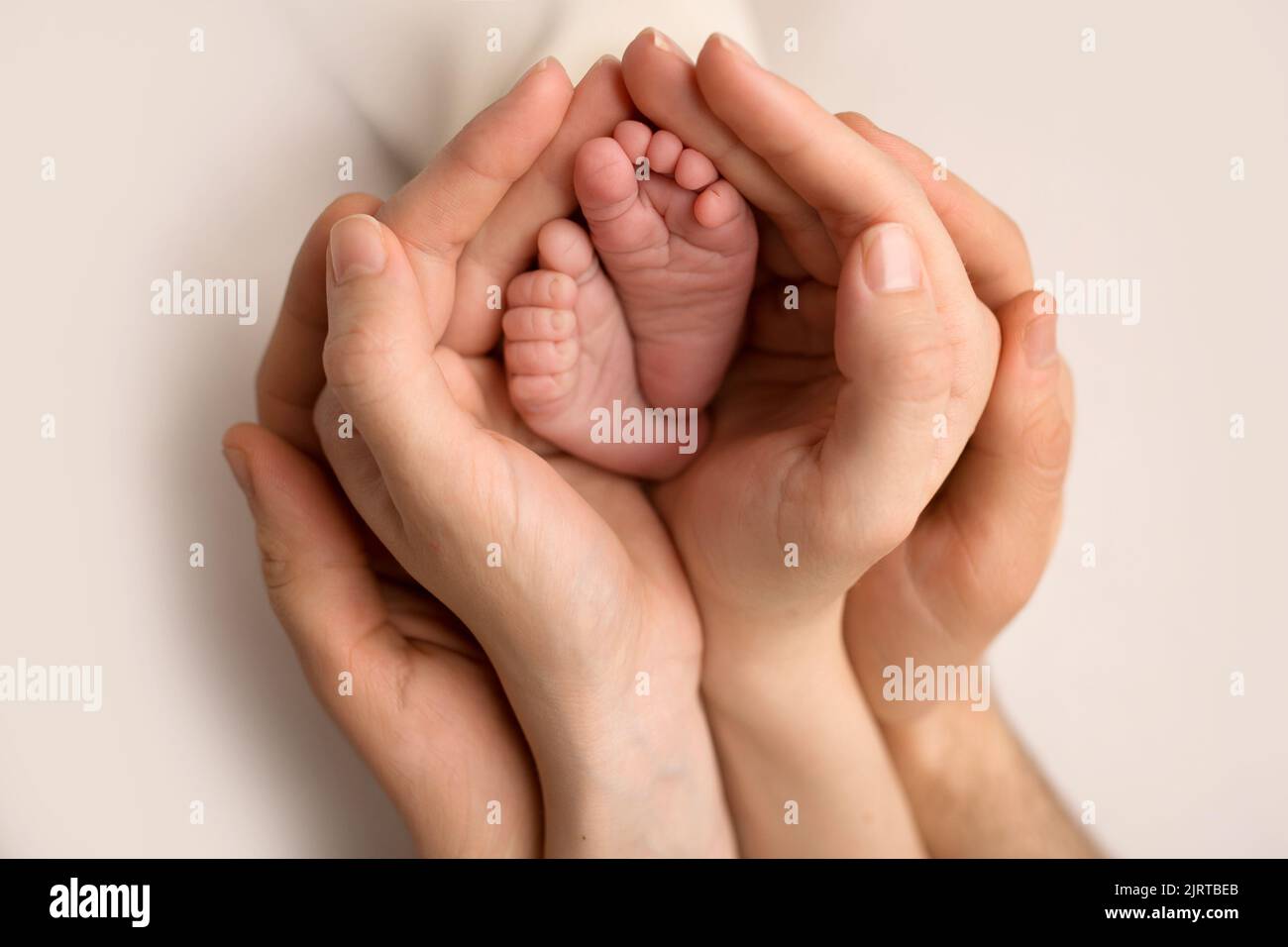 Children's feet in hold hands of mother and father Stock Photo - Alamy