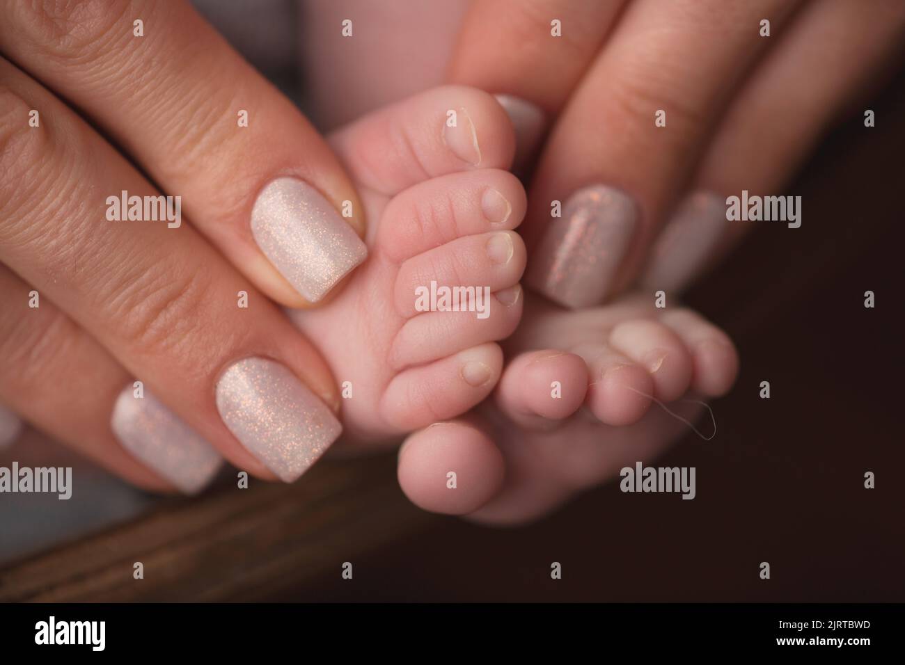 Children's feet in hold hands of mother and father. Mother, father and ...