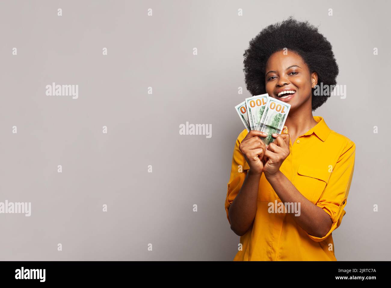 Happy young woman holding hundreds of dollar money banknotes and ...