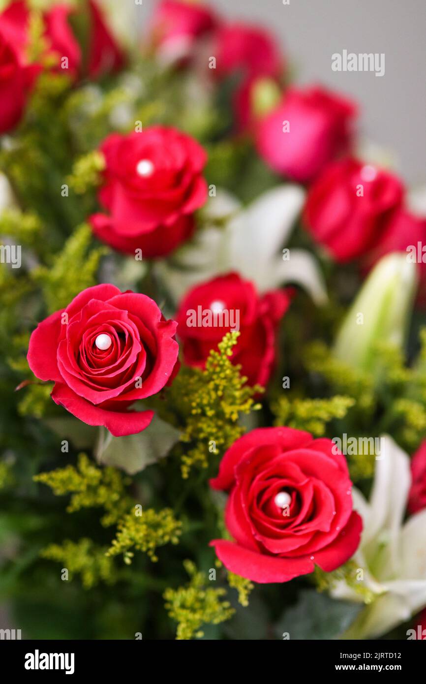 The bouquet of red beautiful roses with pearl on the bud, vertical ...