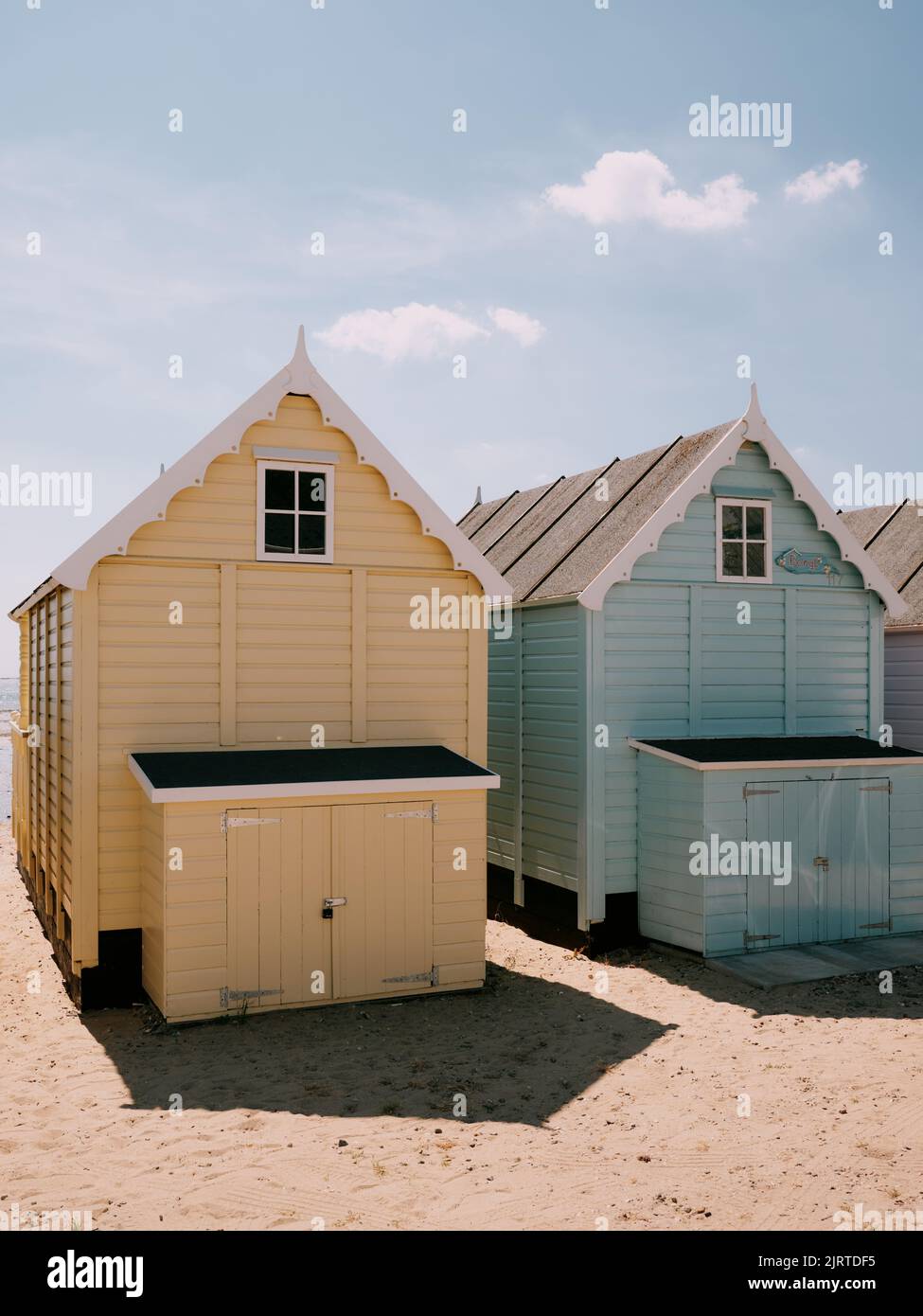 The pastel painted summer beach huts and blue sky on the beach in West ...