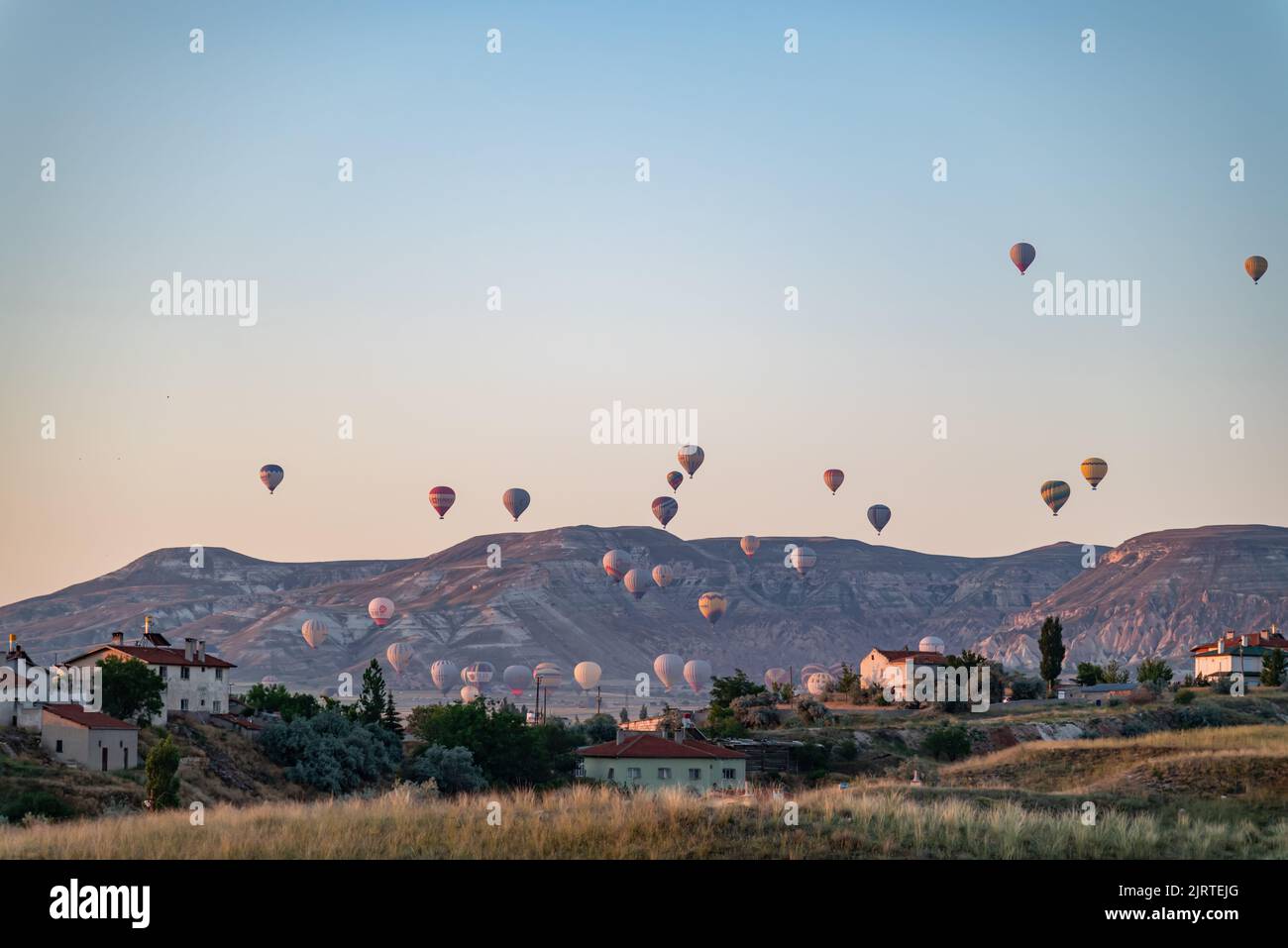 Floating air balloons on the sunrise above the valley in Goreme, view ...
