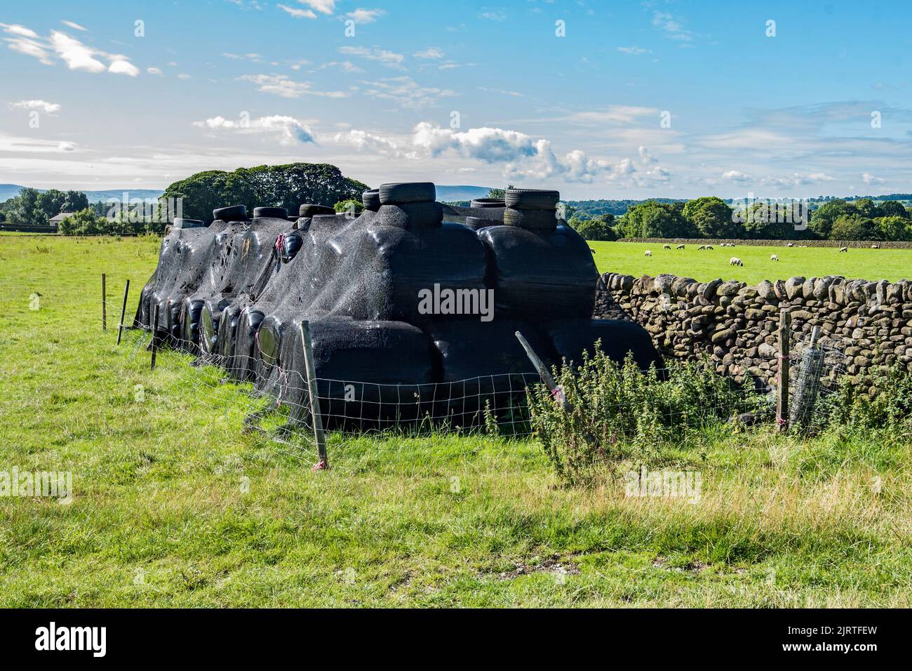Big bale crow protection by farmer using netting Stock Photo - Alamy