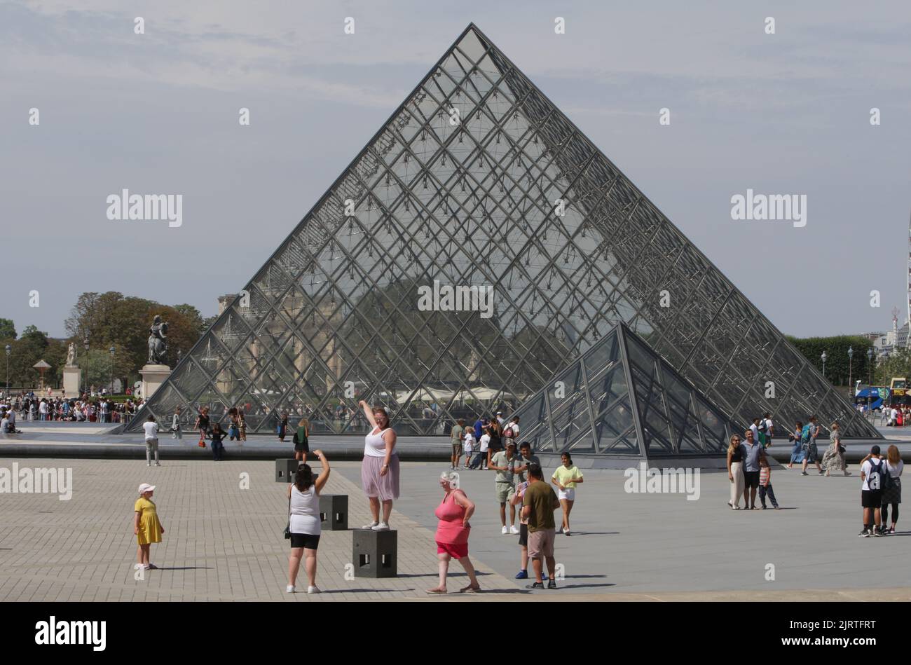 Tourists enjoys near Pyramid at the Louvre Museum during a hot summer ...