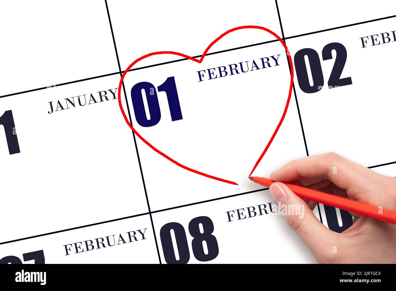 1st day of February. A woman's hand drawing a red heart shape on the ...
