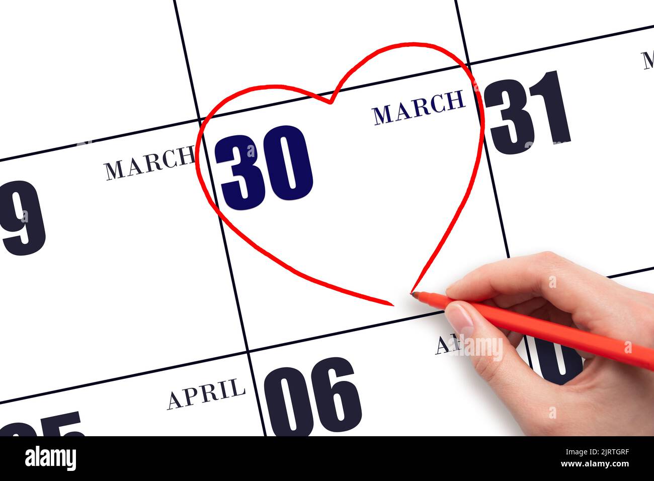 30th day of March. A woman's hand drawing a red heart shape on the ...