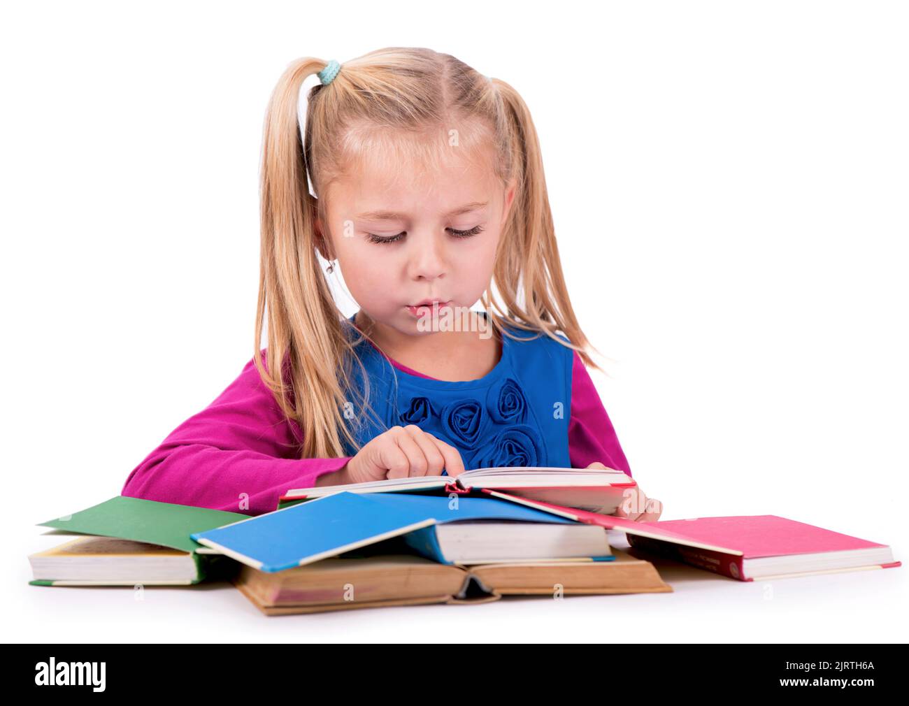 Little smart girl holding a book and reading it, on a white background ...