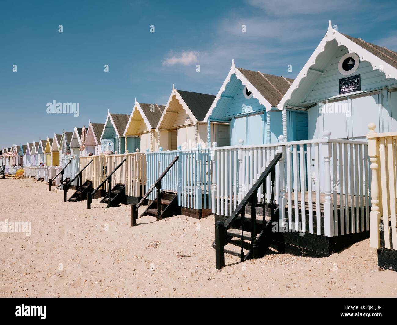 The pastel painted summer beach huts and blue sky on the beach in West ...