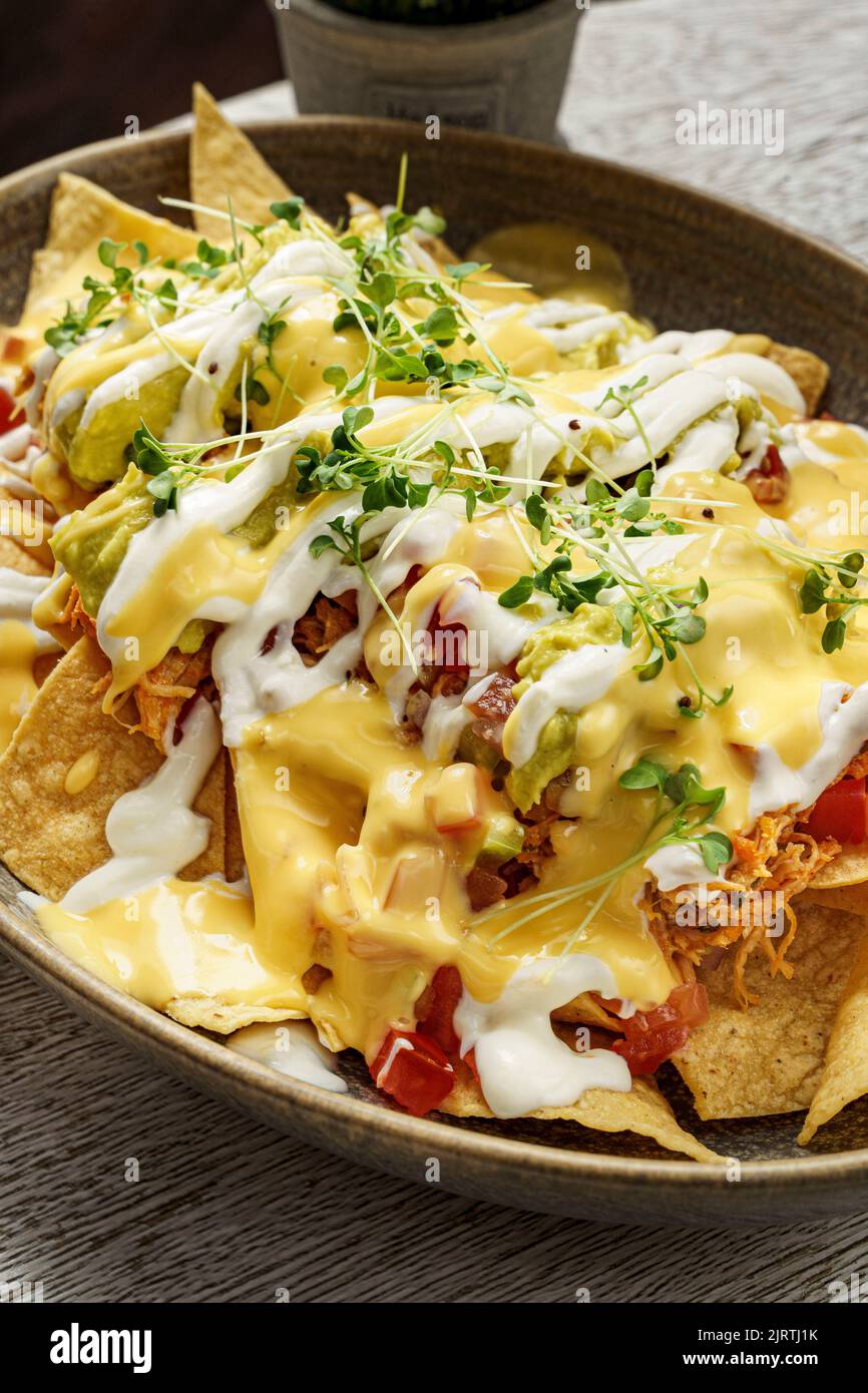 A vertical shot of chicken loaded nachos with cheese Stock Photo - Alamy