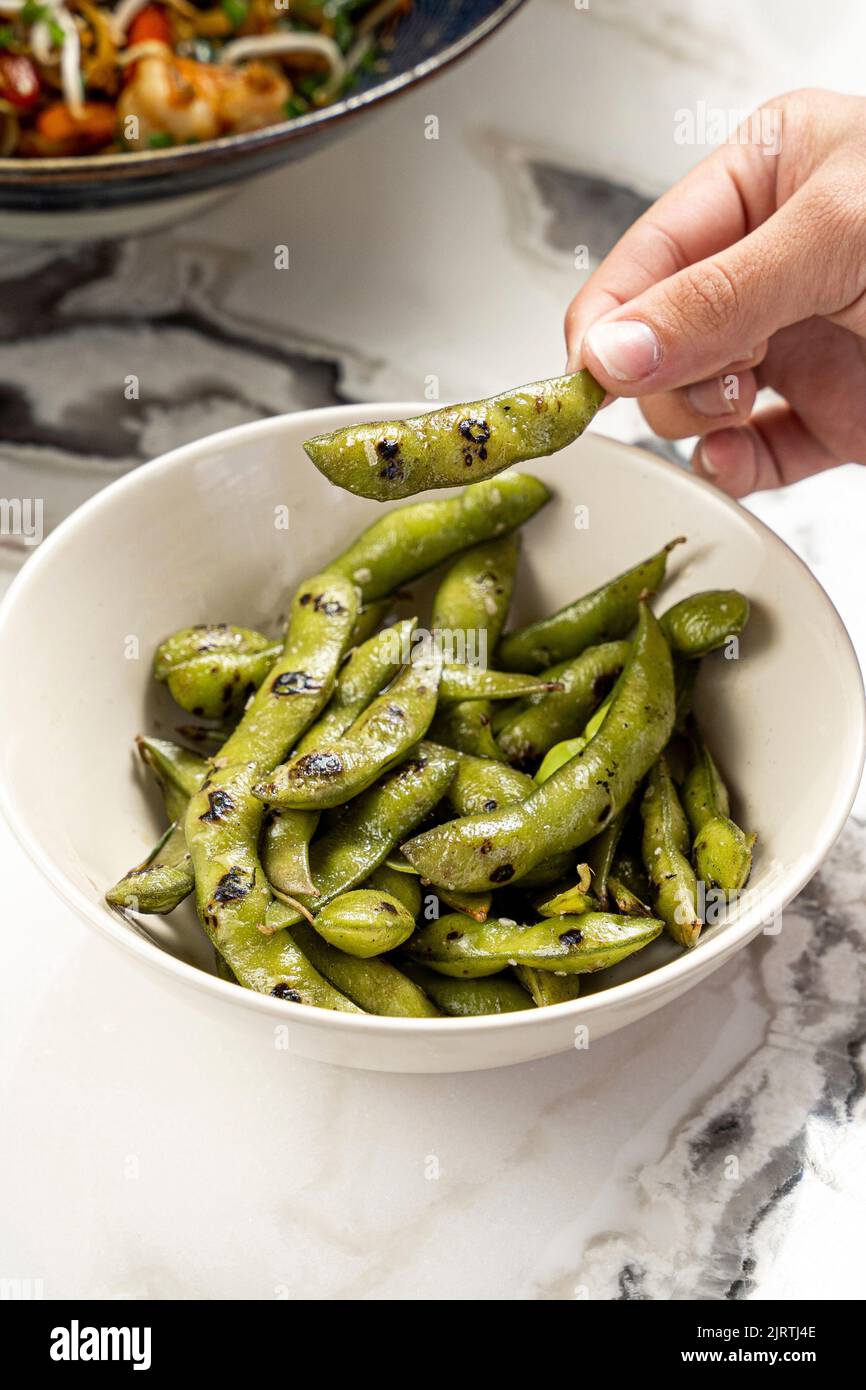 A vertical shot of fried edamame in a white bowl Stock Photo - Alamy