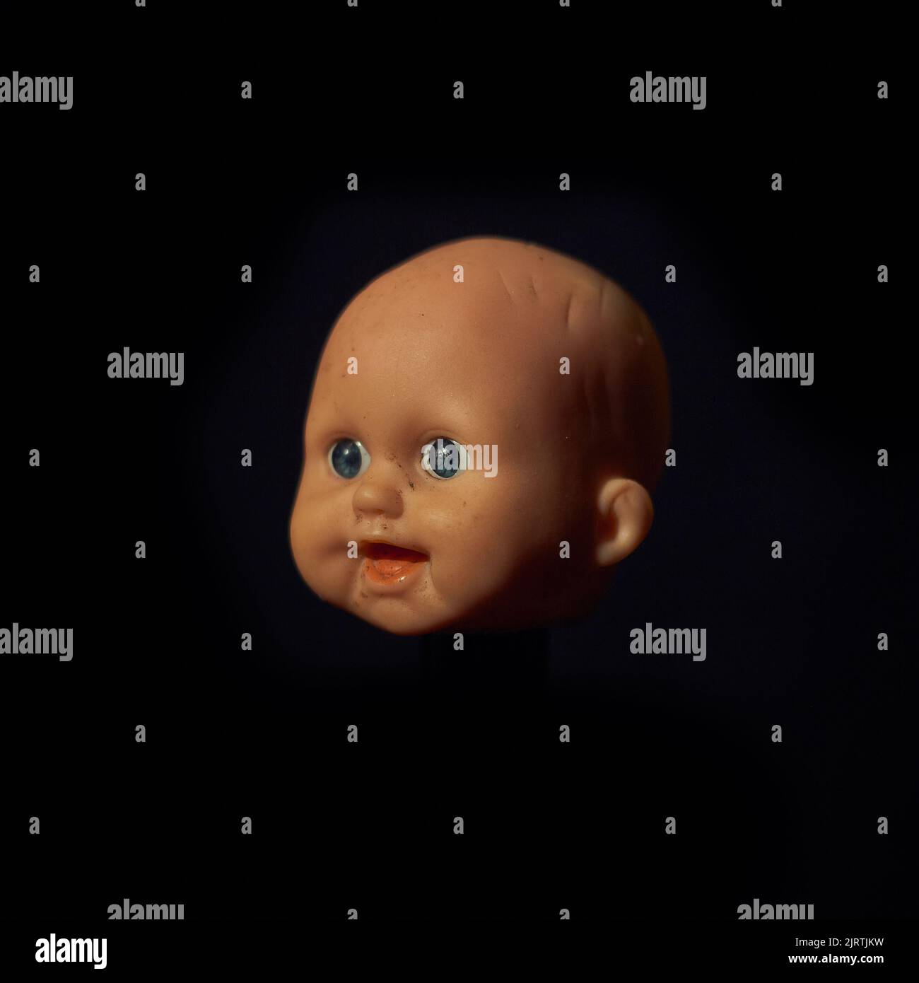 Damaged Dirty Doll head on black background isolated Stock Photo - Alamy