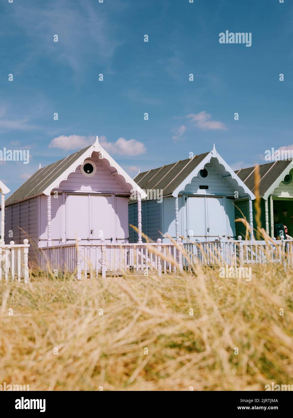 The pastel painted summer beach huts and blue sky on the beach in West ...