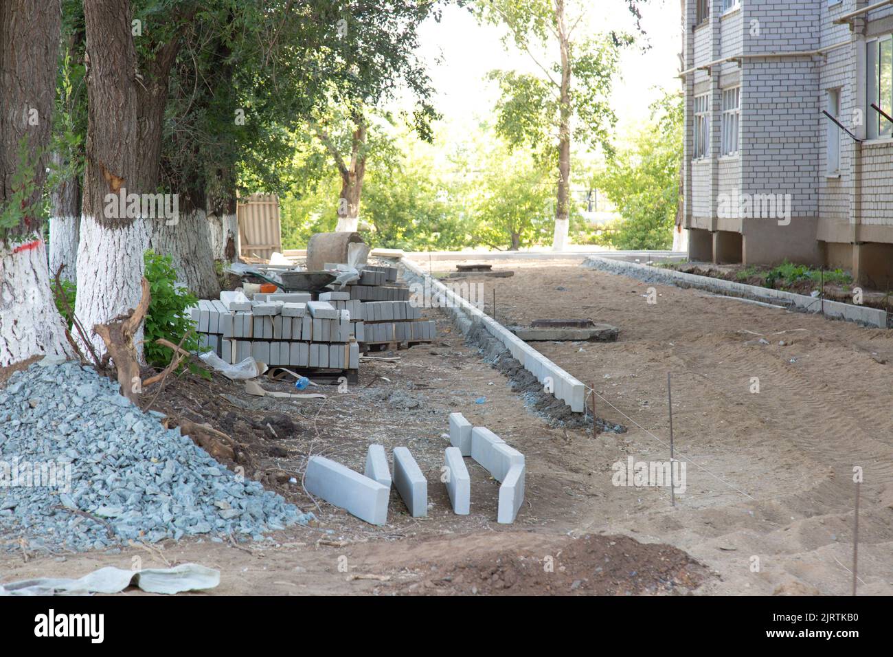 Laying a pedestrian path along the house. Even layer of sand, prepared ...