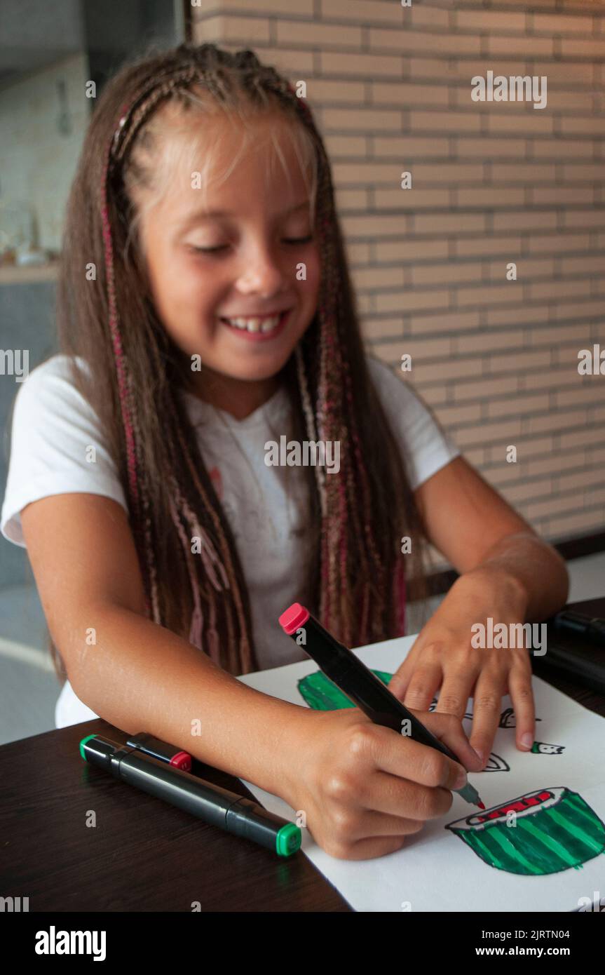 A happy little girl is drawing with markers Stock Photo - Alamy