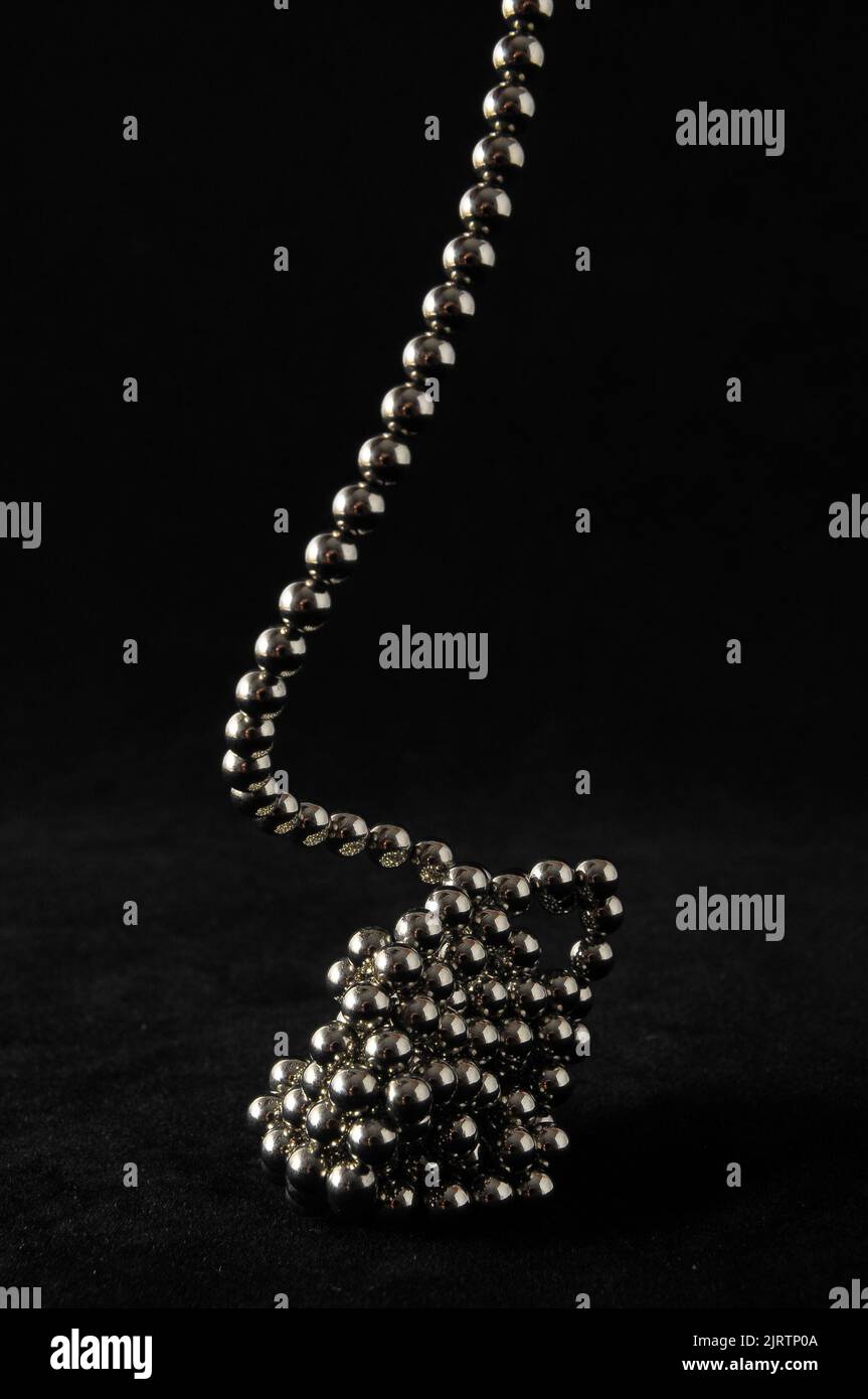 Lot of Round Magnetic Spheres on a Black Background Stock Photo - Alamy