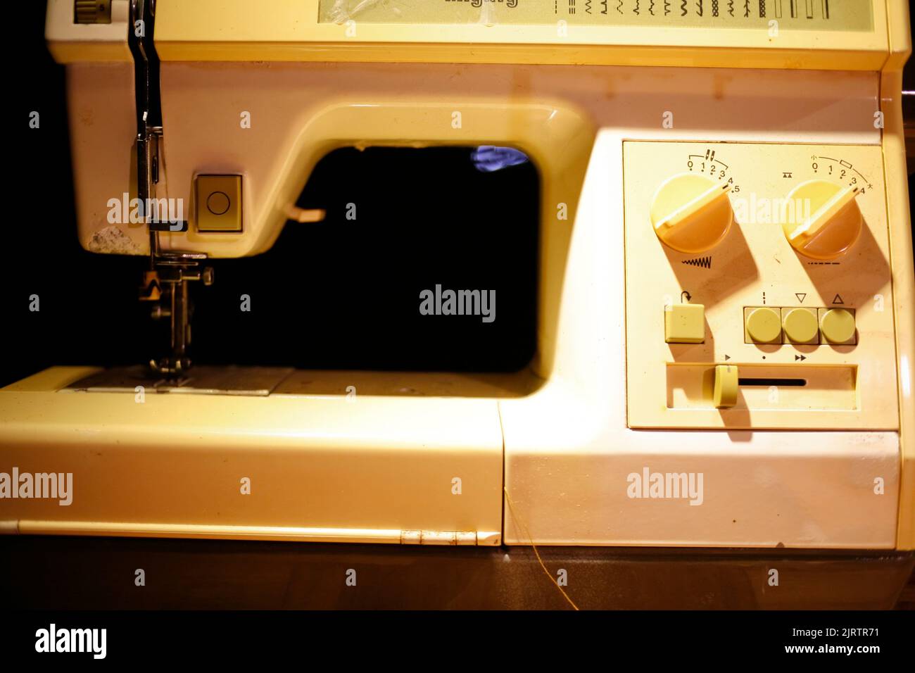 Sewing machine on table in tailor's workshop Stock Photo - Alamy