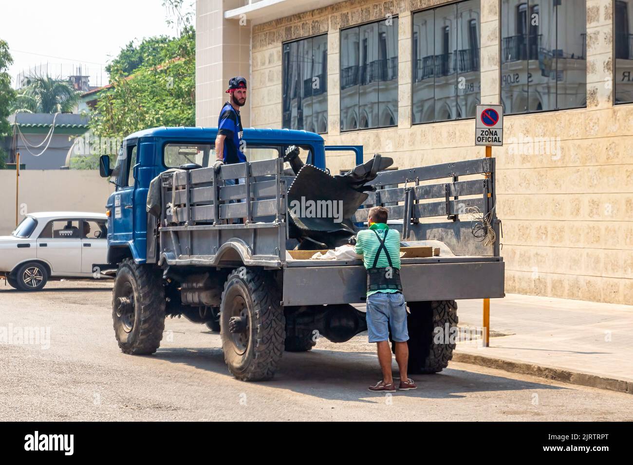 Cuban workers in the back of an obsolete Russian truck. The mode of ...