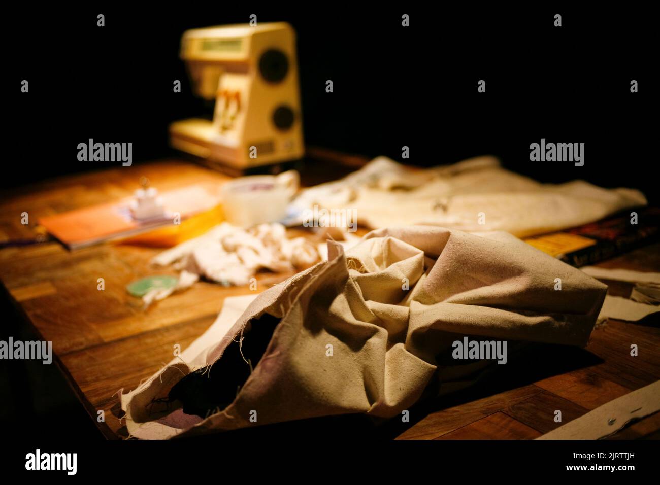 Sewing machine on table in tailor's workshop Stock Photo - Alamy