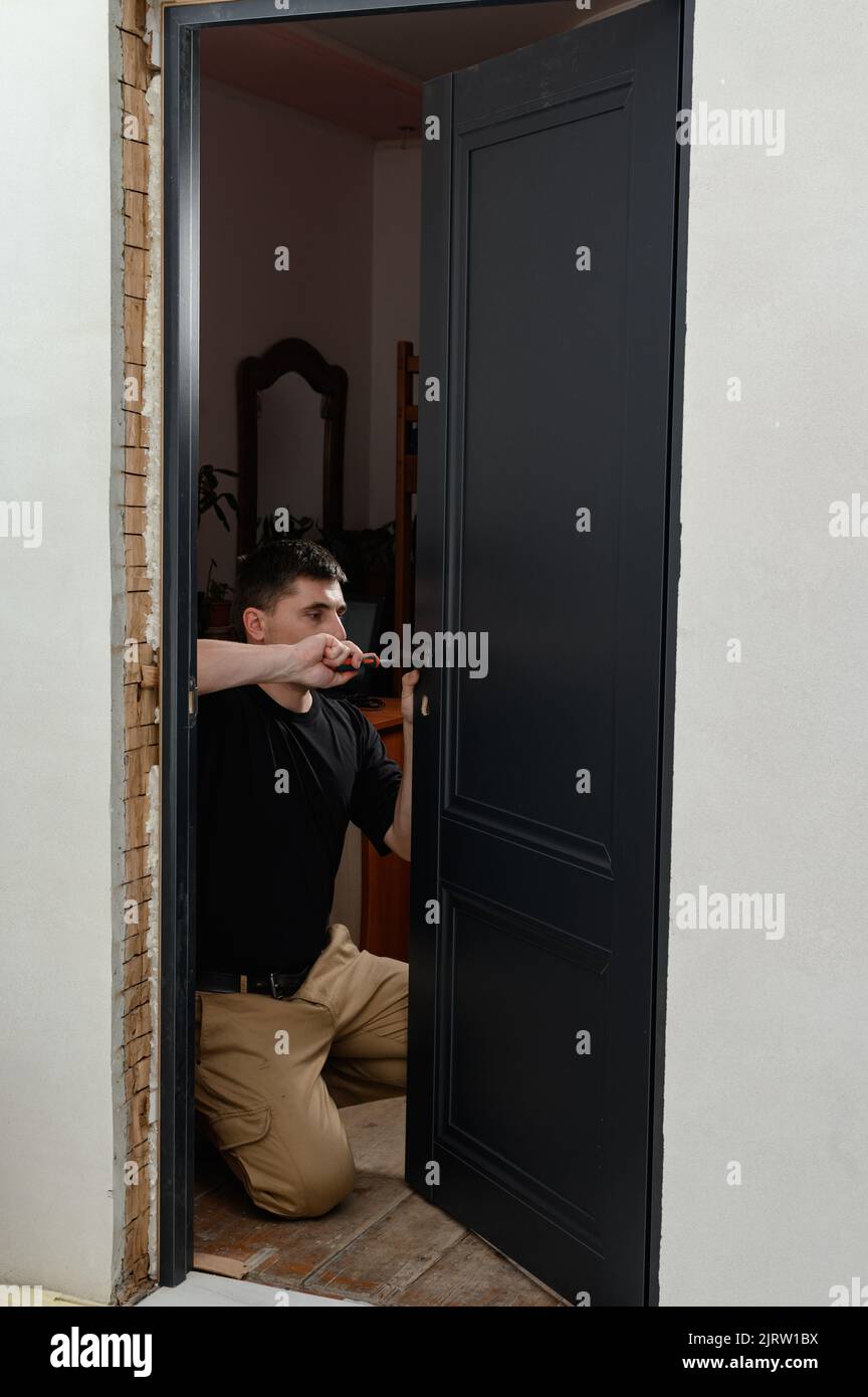 Installation of a door handle on interior doors, carpentry work with ...