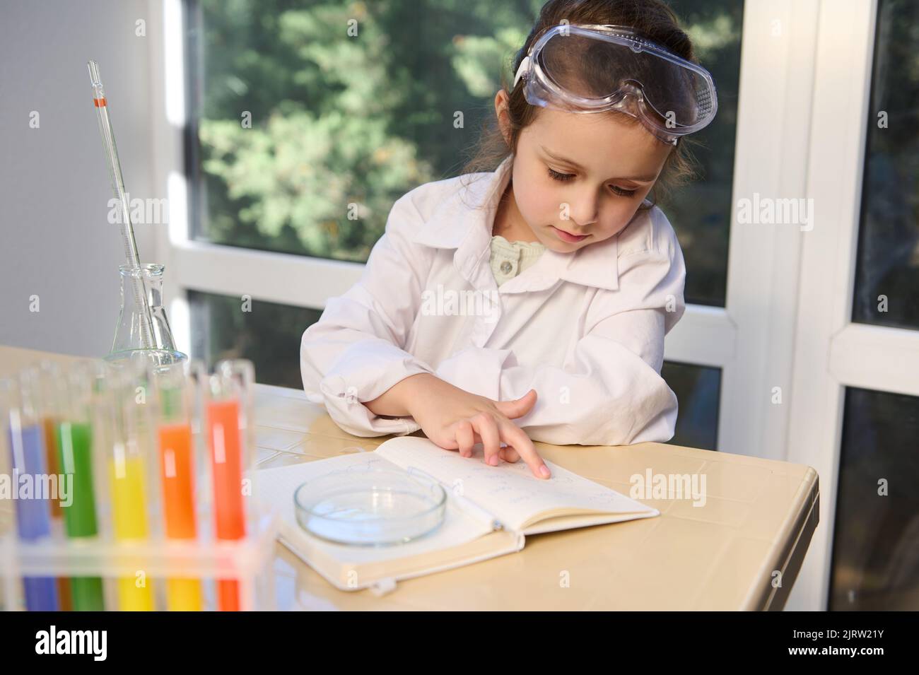 European smart little girl learning chemistry. Fascinating scientific ...
