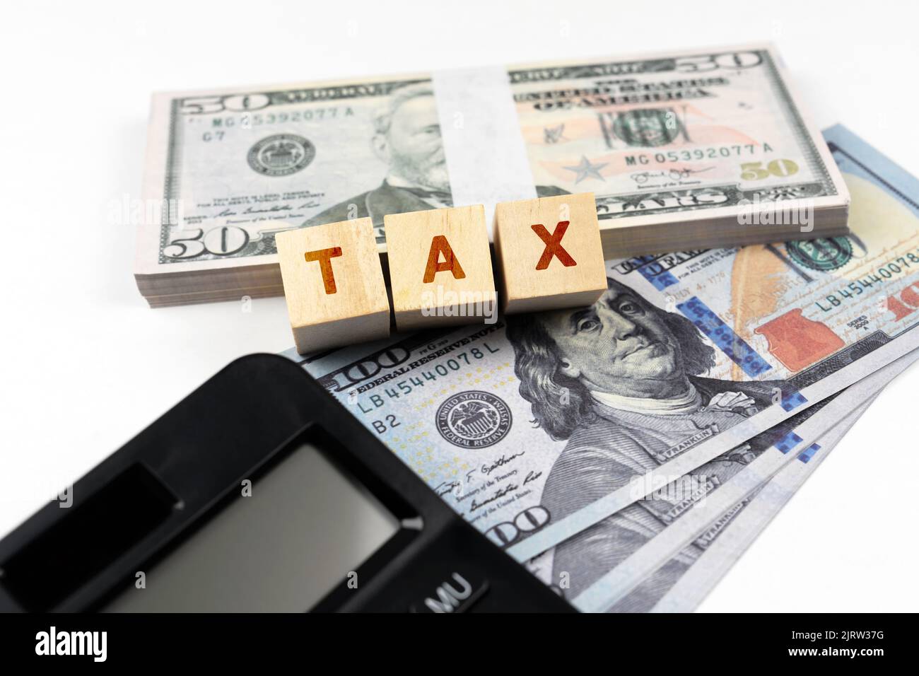 Tax text on wood block with calculator and paper money bill Stock Photo ...