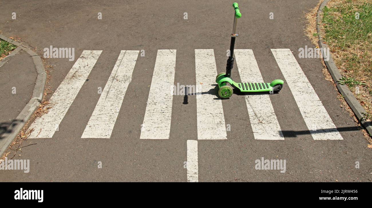 Children at the crosswalk. Children's scooter at the road. Summer ...