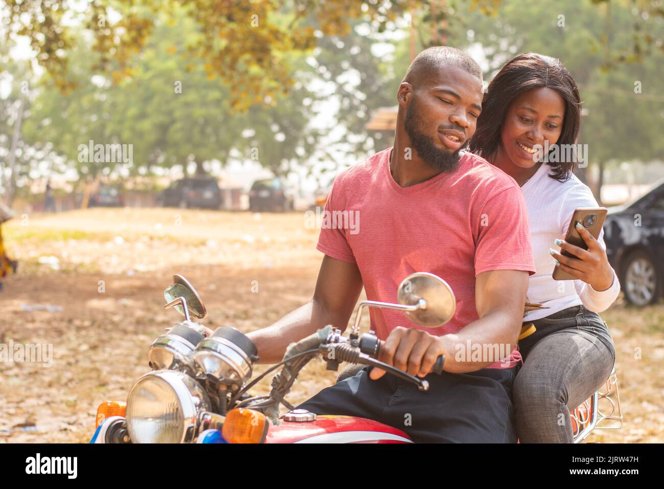 african lady on a bike and the rider view content on phone Stock Photo ...