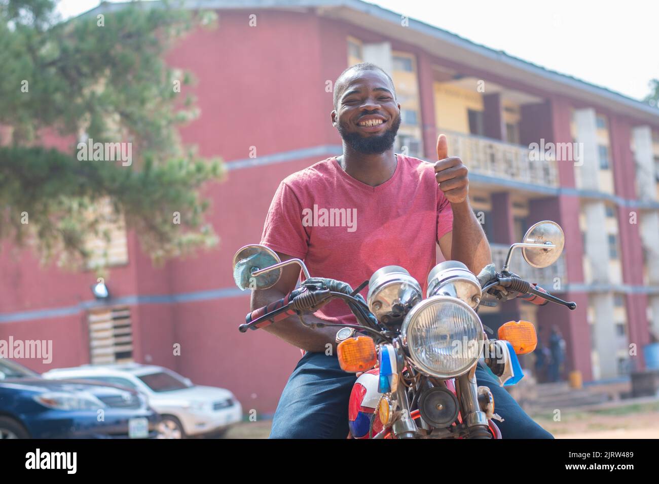 african bike rider does a thumbs up Stock Photo - Alamy
