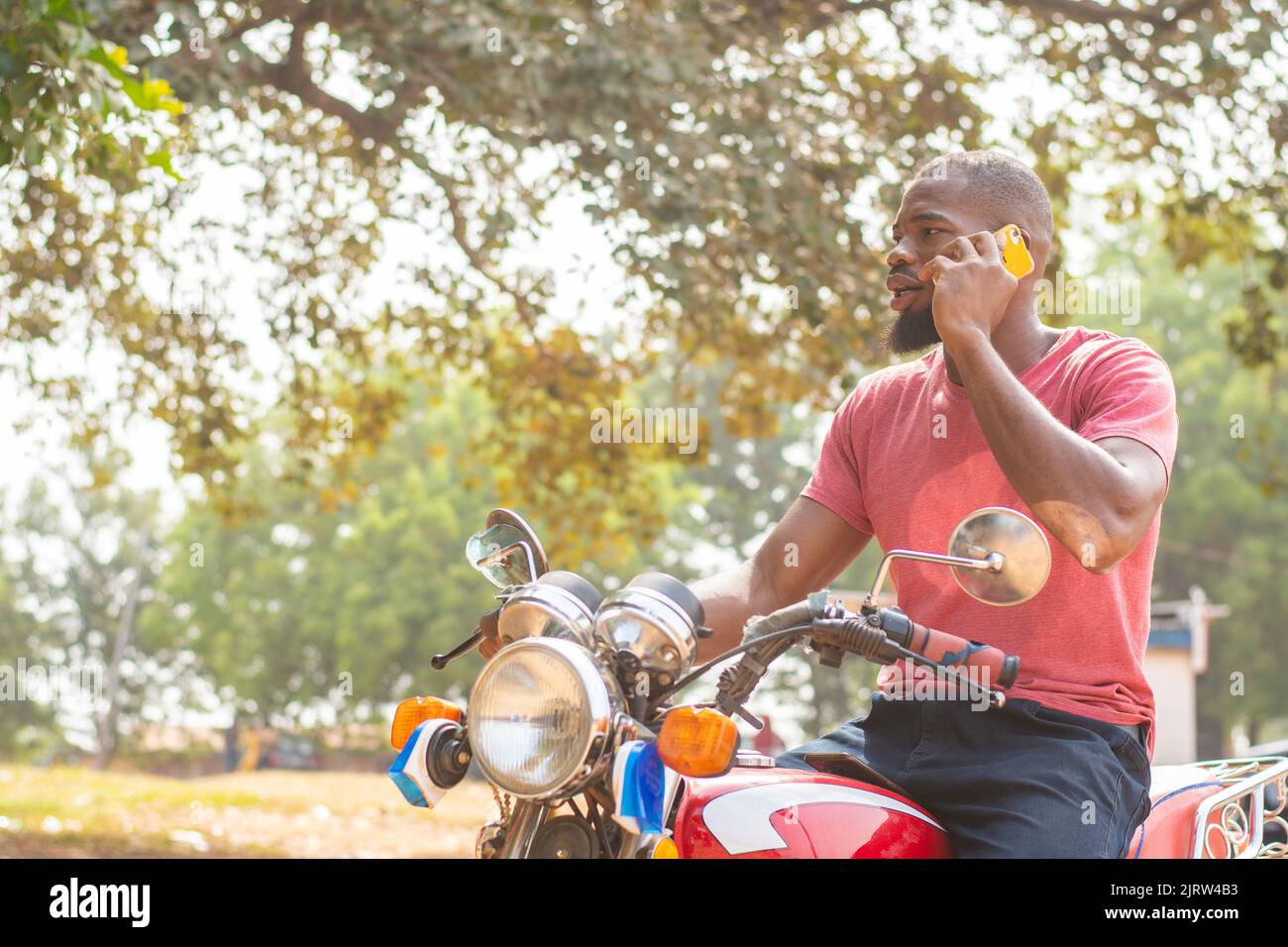 african man on a motorcycle making a phone call Stock Photo - Alamy