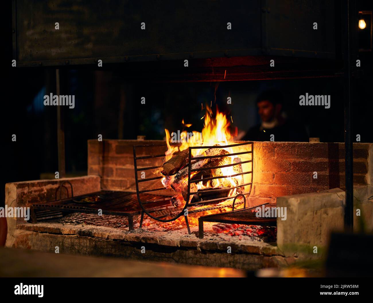 Open fireplace burning with woodblocks with grills on the side Stock ...