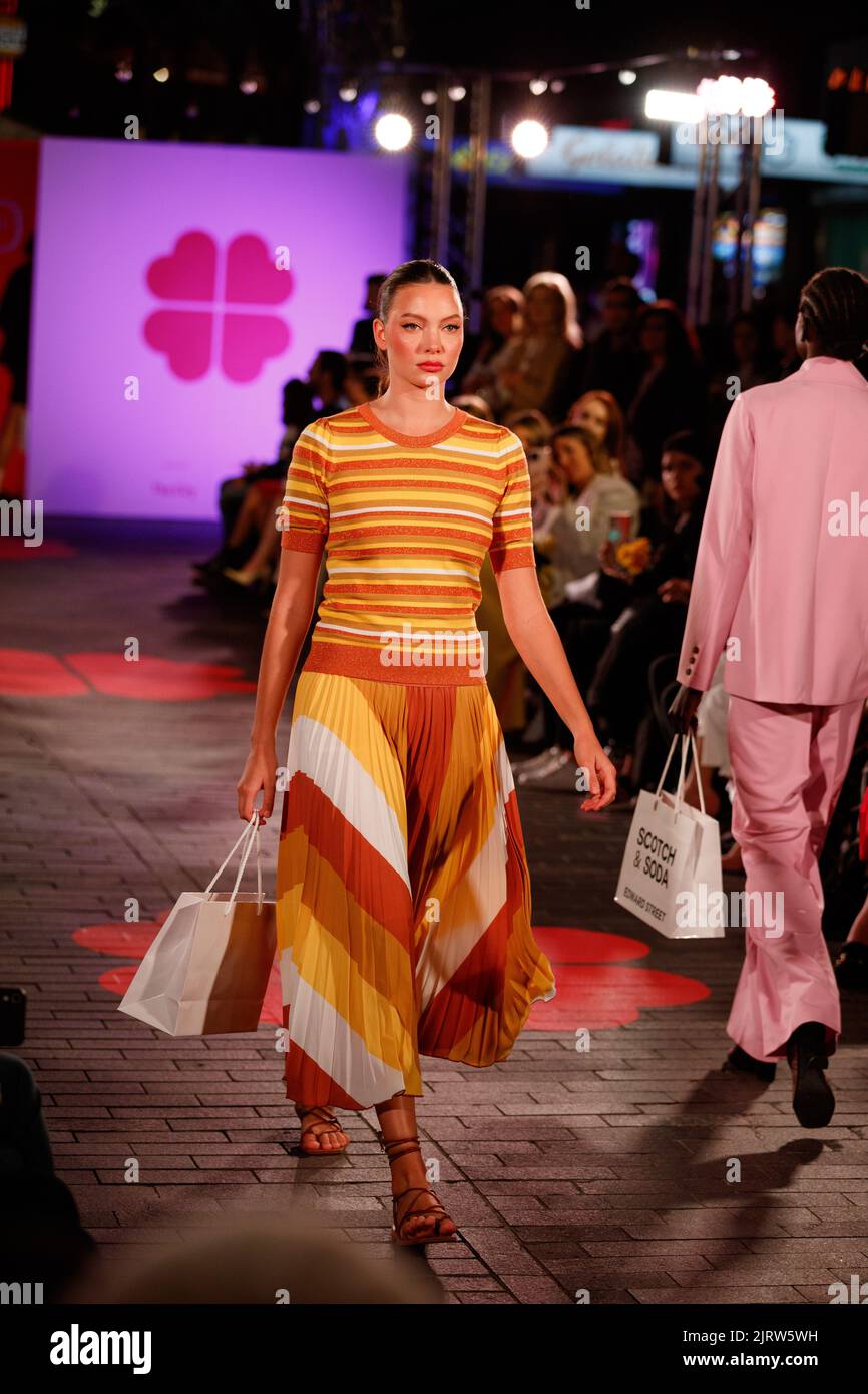 Models walk a fashion runway wearing brands from local and ...