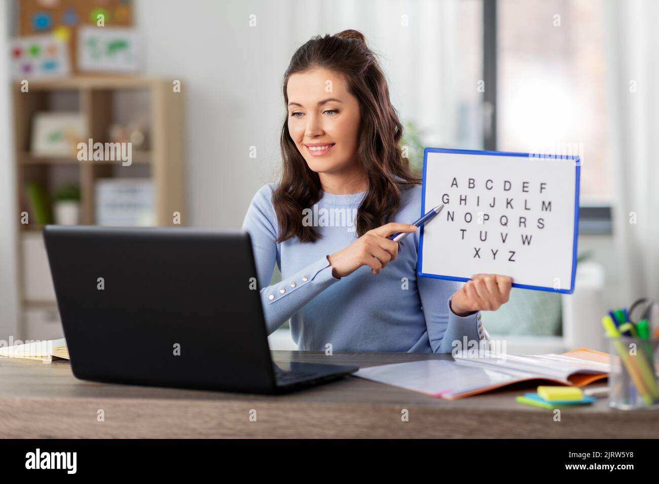 teacher with alphabet having online class at home Stock Photo - Alamy