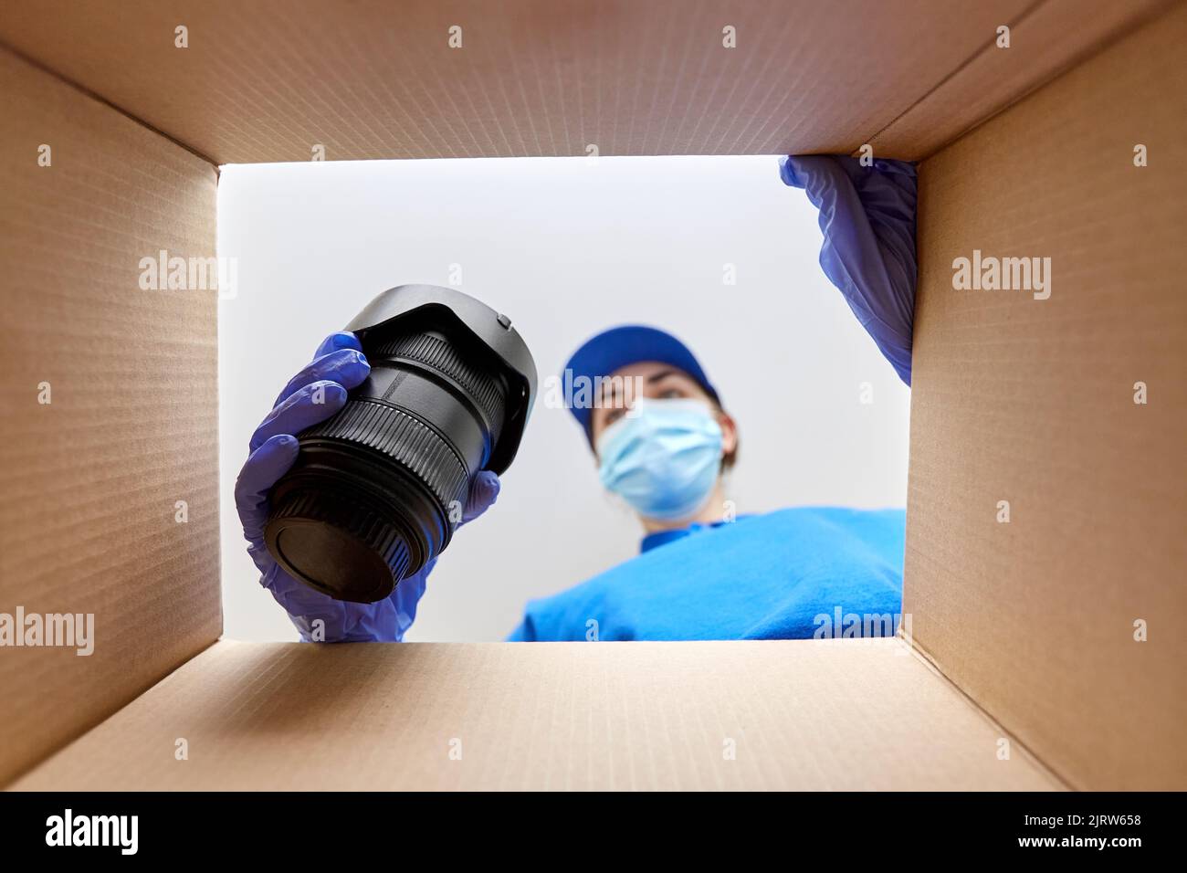 woman in mask packing camera into parcel box Stock Photo - Alamy