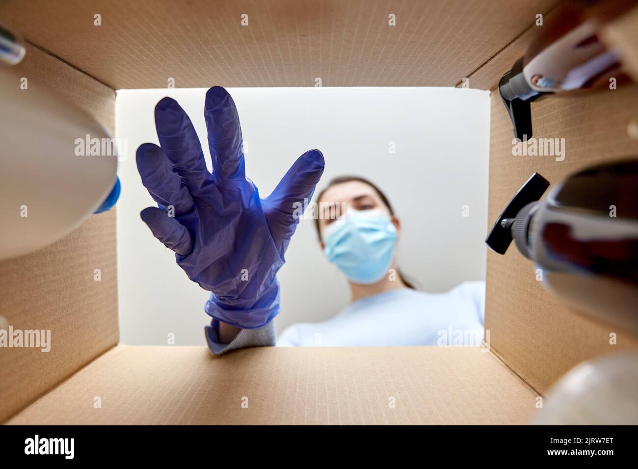 woman in mask unpacking parcel box with cosmetics Stock Photo - Alamy