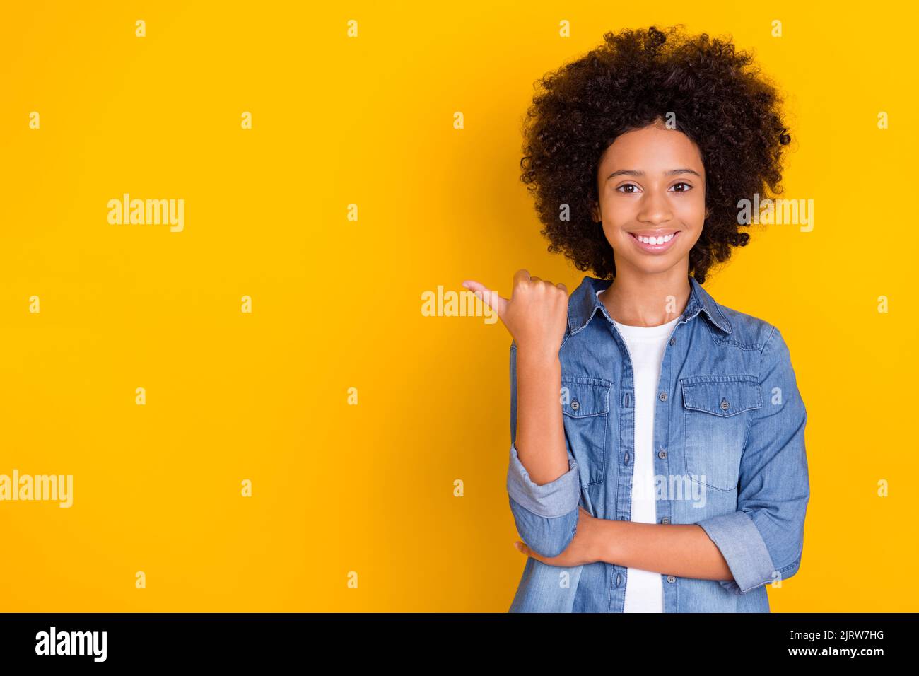 Portrait of beautiful trendy cheery teen-aged girl showing copy blank ...